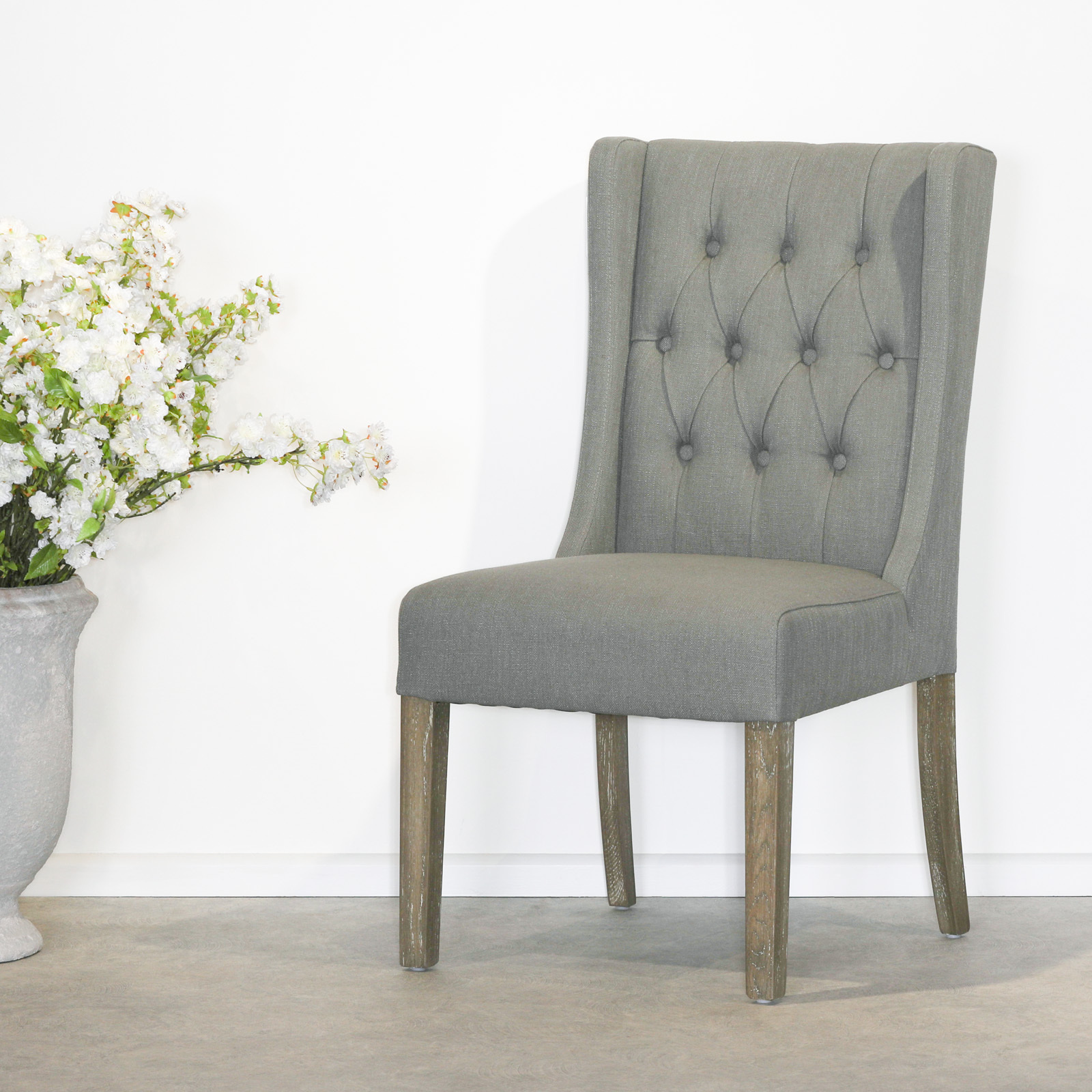 Grey Buttoned Back Dining Chair embraces the sculptural curves